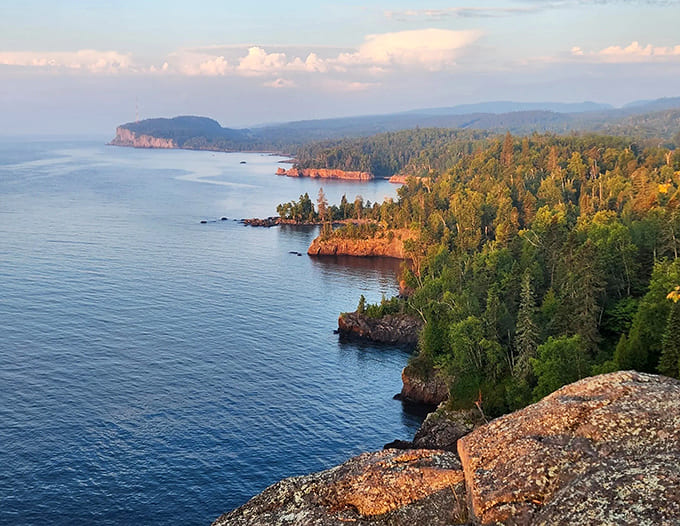 Sunset paints Shovel Point's rugged coastline in golden hues, where Lake Superior stretches endlessly toward the horizon.
