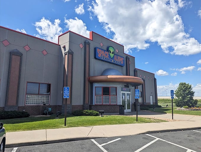 The unassuming gray building with its iconic blue sign and green alien mascot stands ready to beam up hungry travelers from the Minnesota landscape.