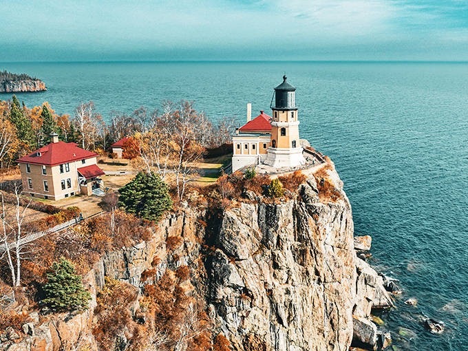 Split Rock Lighthouse stands majestically on its cliff, like nature's perfect exclamation point against Minnesota's North Shore. The autumn colors frame this iconic beacon in a fiery embrace.