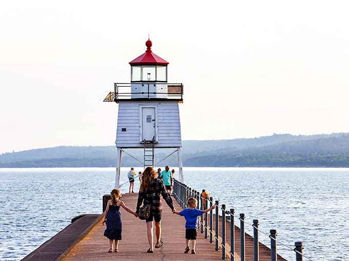 The iconic white lighthouse stands sentinel at the end of the breakwater, beckoning visitors to make the rewarding journey across Lake Superior's waters.