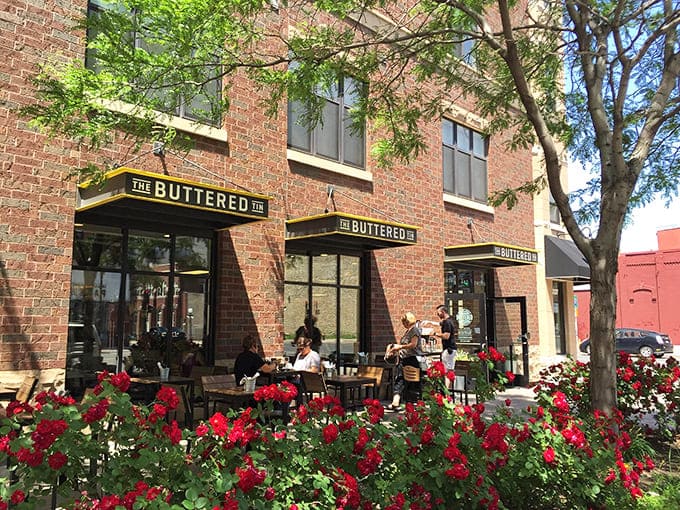 The Buttered Tin's welcoming brick exterior with cheerful yellow awning invites passersby to step into a world of culinary comfort in St. Paul's Lowertown.