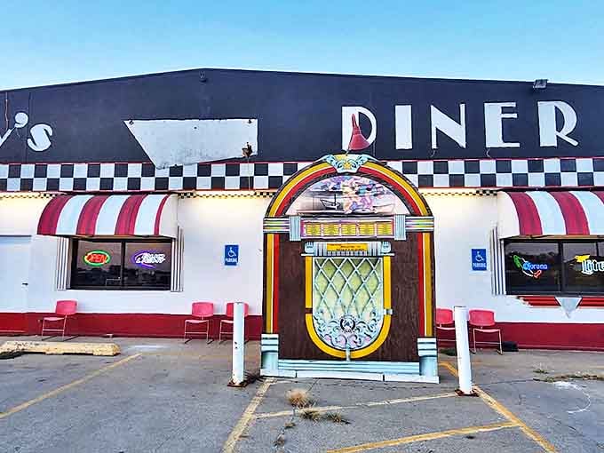 Woody's exterior beckons with its giant jukebox entrance and classic checkered trim &ndash; like a time portal disguised as a diner.