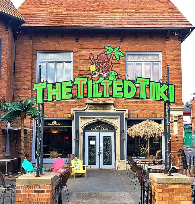 The Tilted Tiki's brick exterior hides a tropical surprise, with its vibrant signage promising an escape from Minnesota's notorious winters.