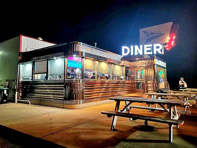 The gleaming chrome exterior of The Comet Diner glows like a beacon in the night, promising sweet nostalgia and even sweeter treats inside.