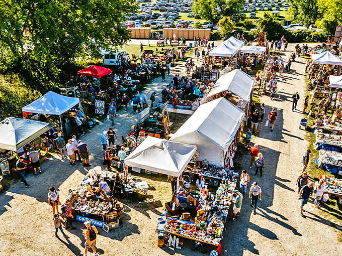 Aerial view of Traders Market bustling with treasure hunters &ndash; a sea of white tents and colorful wares stretching across the Minnesota countryside.