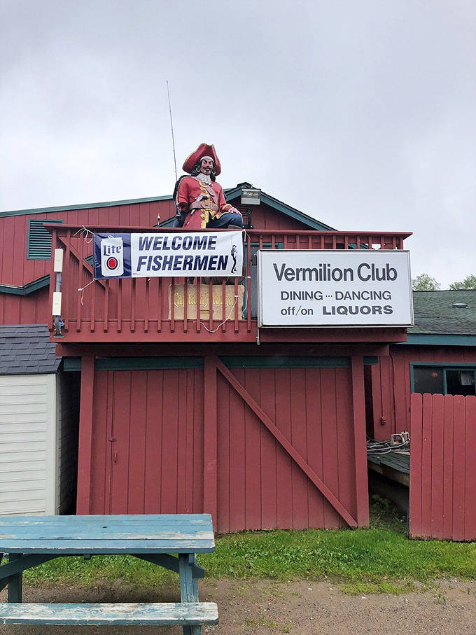 A pirate captain mannequin stands guard atop the rustic red Vermilion Club, welcoming hungry travelers with the promise of hearty Minnesota hospitality.