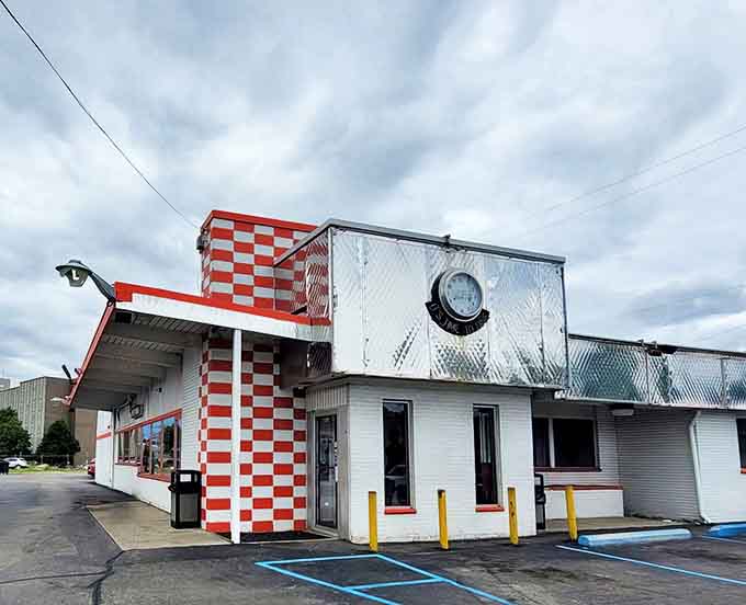 The iconic red and white checkerboard exterior of West Side Diner stands as a beacon of nostalgia on Flint's Ballenger Highway, promising timeless comfort inside.