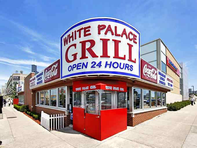 The iconic White Palace Grill sign glows like a beacon for hungry souls, promising 24-hour comfort in Chicago's urban landscape.