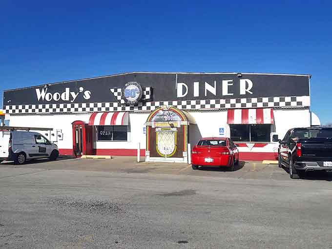 Woody's exterior welcomes visitors with its iconic black-and-white checkered facade and vintage signage, a roadside beacon of nostalgia.