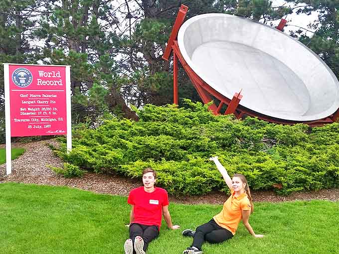 The World's Largest Cherry Pie Pan stands proudly against Michigan pines, a monument to dessert ambition that defies conventional baking logic.