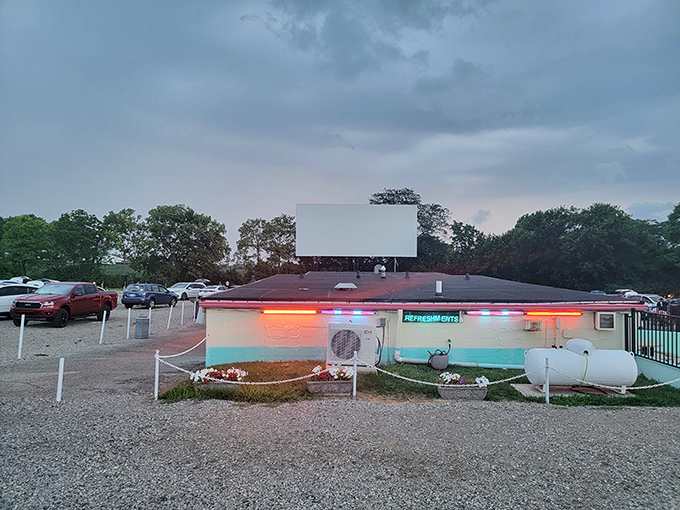 The Holiday Auto Theatre's vintage exterior glows with neon promise as dusk settles &ndash; a beacon of nostalgia in Hamilton, Ohio.