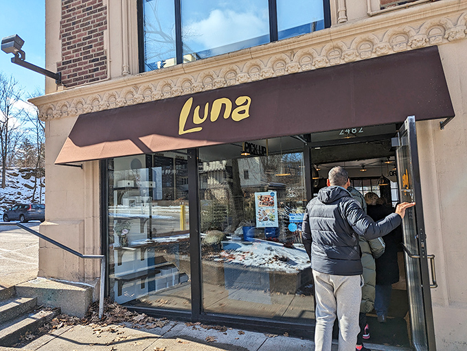 Luna's welcoming storefront beckons with promises of buttery delights, its brown awning like a chocolate drizzle atop the historic brick building.