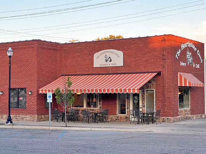The brick exterior of Hearthstone Oven beckons with its cheerful striped awning, promising homemade delights within this Ithaca treasure.