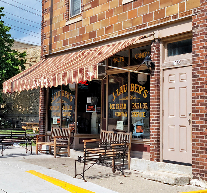 That striped awning and brick facade whisper promises of simpler times when the hardest decision was choosing between chocolate and vanilla, and honestly, both choices were correct.