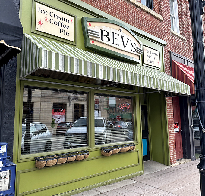 The cheerful green storefront of Bev's Cafe beckons hungry visitors with promises of burgers, ice cream, and small-town charm.
