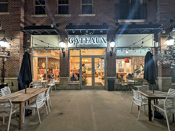 The glowing storefront of G&acirc;teaux P&acirc;tisserie beckons like a lighthouse for dessert lovers, promising sweet salvation under twinkling patio lights.