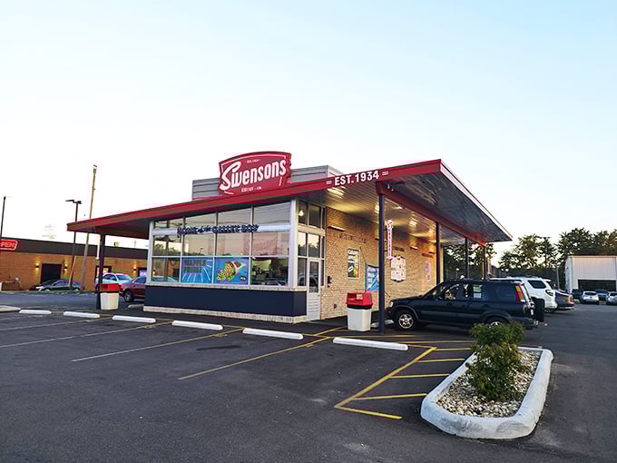 The iconic Swensons Drive-In exterior stands as a beacon of retro charm, its red awning and brick facade promising delicious nostalgia with every visit.