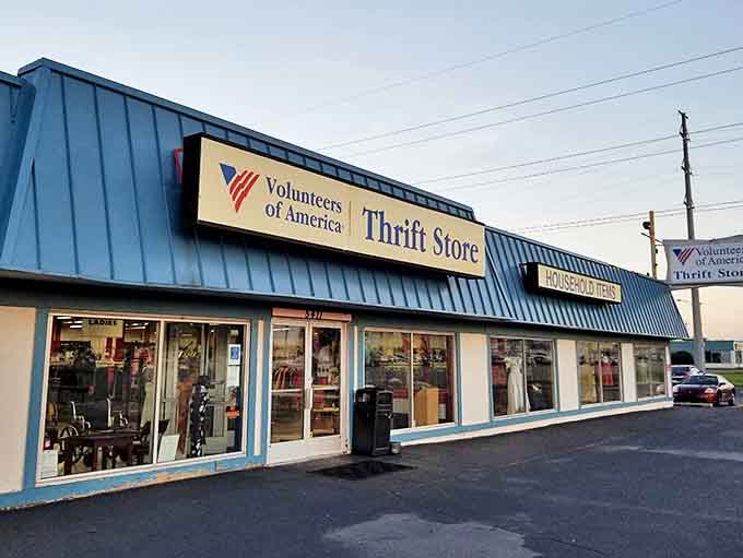 The blue-roofed Volunteers of America Thrift Store stands ready for treasure hunters, its modest exterior hiding countless wonders within.