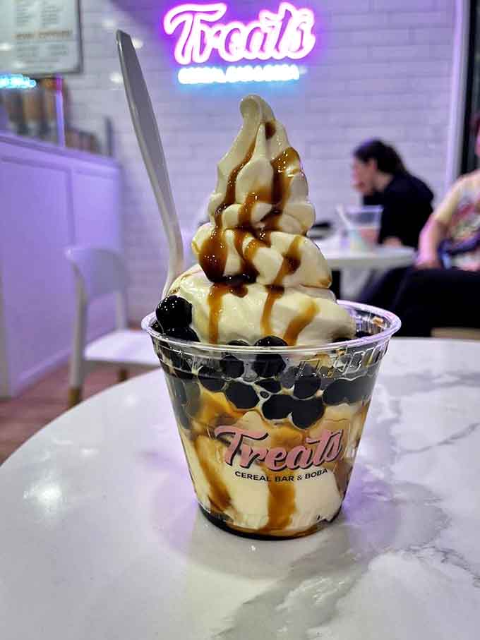 Brown sugar boba nestled beneath creamy soft serve creates a textural playground where chewy meets smooth in perfect harmony.