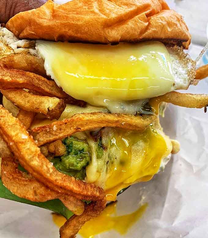 Perched atop a mountain of golden fries, this sandwich isn't just lunch&mdash;it's an achievement, with an egg that runs like a victory lap.