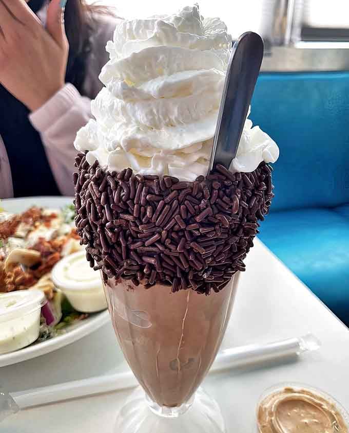 This chocolate milkshake isn't just a dessert &ndash; it's an engineering marvel topped with enough whipped cream to make clouds jealous.
