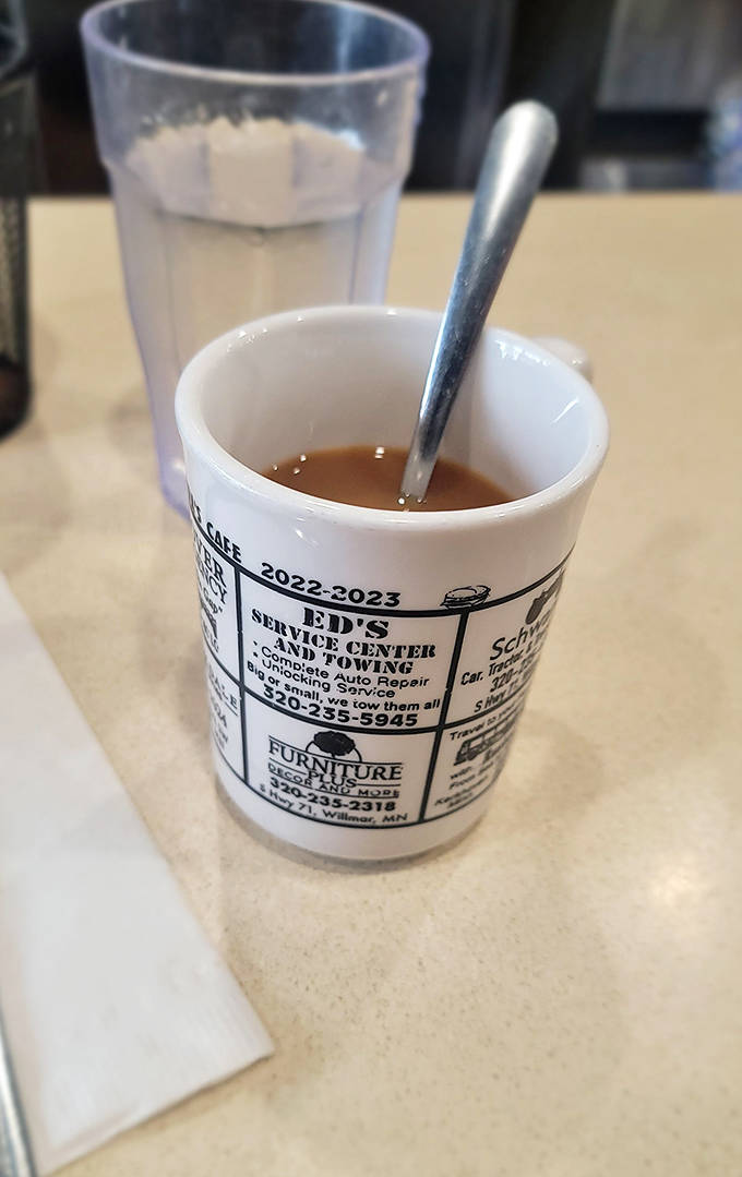 Coffee served in mugs advertising local businesses &ndash; because at Frieda's, even your caffeine fix supports the community while warming your hands.