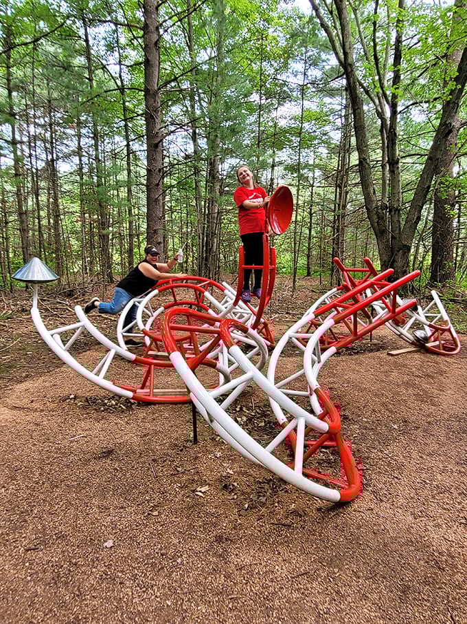Visitors interact with this playful red and white sculpture that seems designed by aliens who've only heard about human playground equipment.