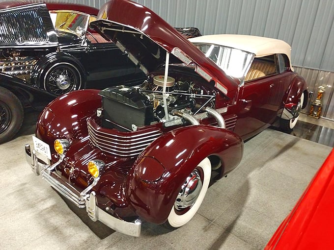 This stunning maroon Cord convertible, hood up, is a beautifully preserved classic. That gorgeous engine detail is waiting for an admirer!