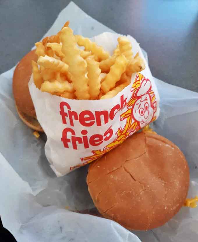 Double cheeseburgers with fries in that classic fast-food presentation that somehow tastes better when it's made with actual care and quality ingredients.