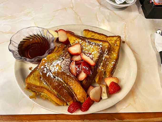 French toast adorned with fresh strawberries and a dusting of powdered sugar &ndash; breakfast that looks like dessert but feels like permission.