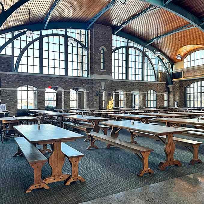 Where medieval meets modern: Long wooden tables invite community dining under arched windows that flood the space with natural light.