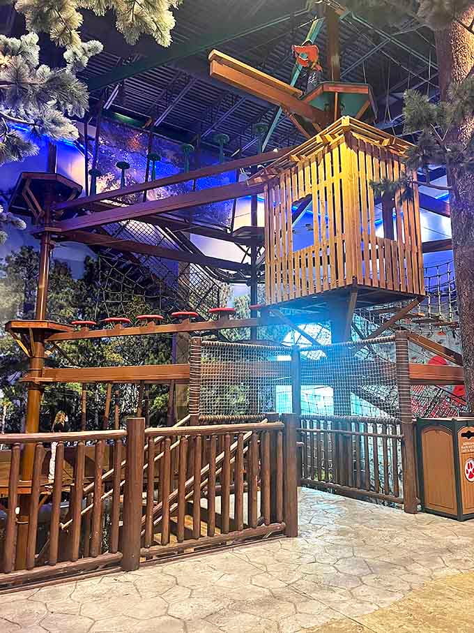 The indoor adventure course challenges brave explorers to navigate wooden pathways high above the ground, safely harnessed but feeling wonderfully daring.