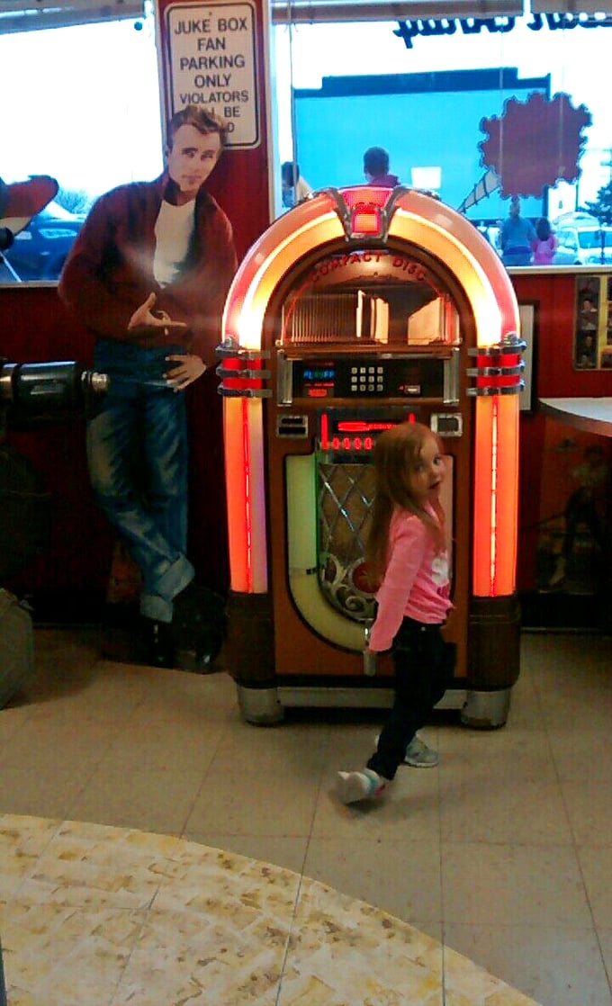 James Dean watches approvingly as a young visitor discovers the jukebox – two icons of American culture meeting across generations.