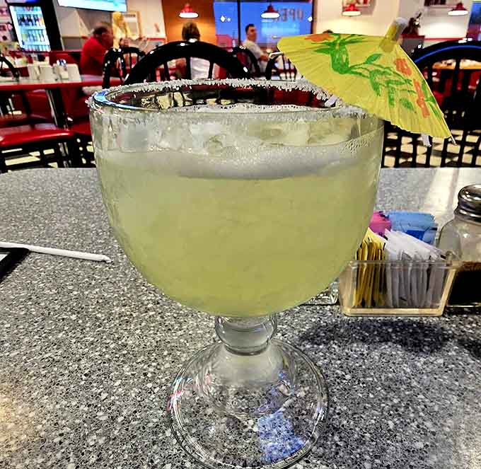 Their margarita arrives in a glass big enough to require a lifeguard, complete with salt rim and that tiny umbrella you secretly love.