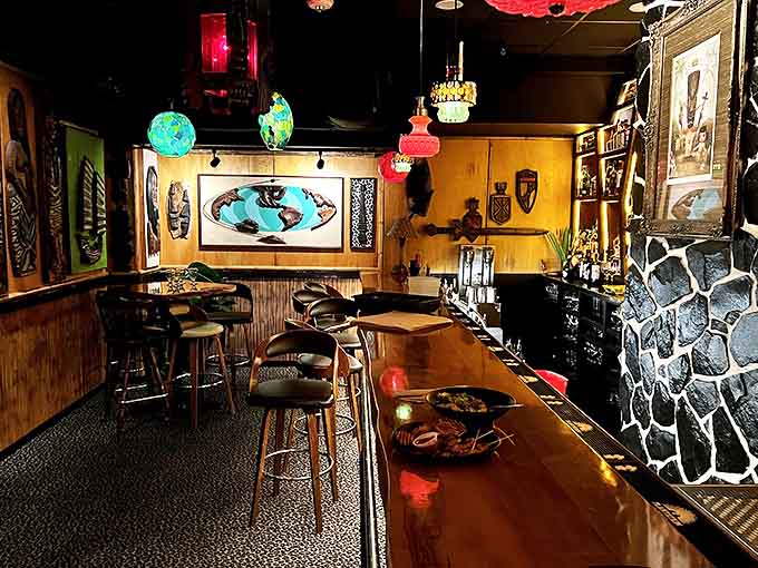 The bar area glows with amber light, showcasing an impressive collection of spirits behind a counter adorned with geometric patterns.