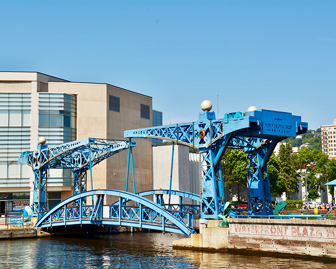 The Minnesota Slip Bridge's brilliant blue span pivots with mechanical precision, a working piece of functional art.