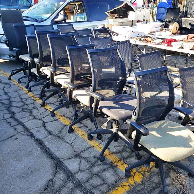 Office chairs lined up like a corporate chorus line – practical seating solutions for work-from-home warriors at bargain prices.