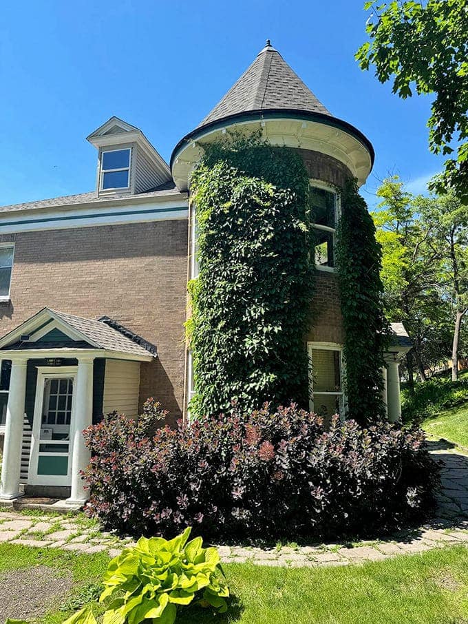 The castle's distinctive turret, wrapped in climbing greenery, stands like a sentinel watching over Big Stone Lake's shimmering waters.