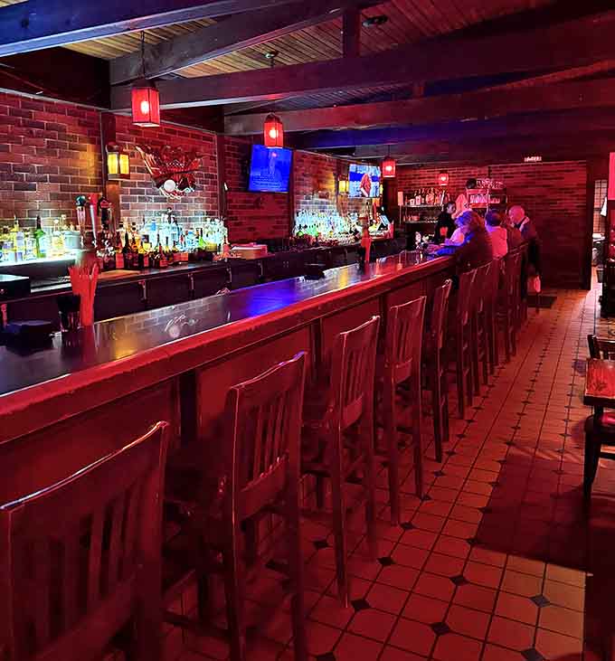 The bar stretches invitingly, each stool promising good drinks, good conversation, and a front-row seat to culinary magic.