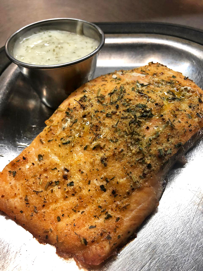 Herb-crusted salmon cooked to flaky perfection, served with a side of creamy dill sauce that complements without overwhelming the delicate fish.