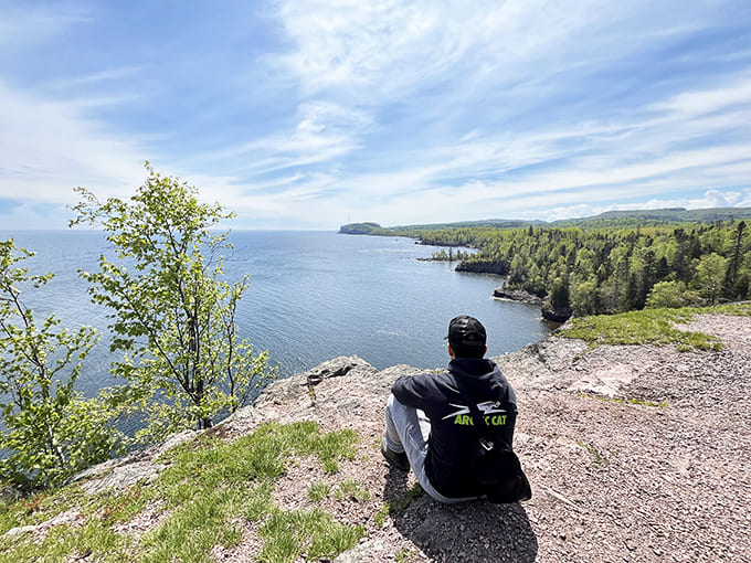 A moment of quiet contemplation as a visitor absorbs the panoramic majesty of Lake Superior's endless horizon.