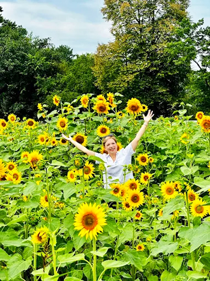 Pure joy captured! A visitor celebrates the simple pleasure of being surrounded by thousands of nature's happiest flowers.