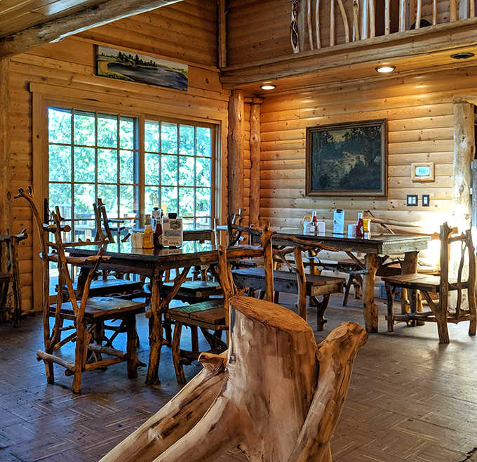 Rustic charm meets culinary creativity in this log-cabin dining space, where every table offers a view of artisanal burger craftsmanship.