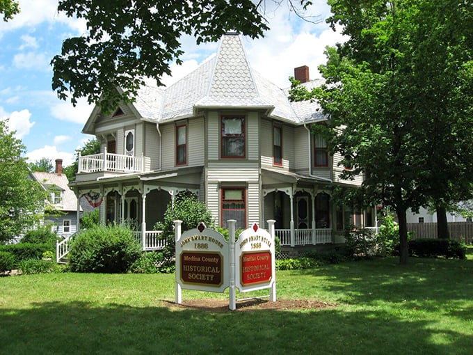 The John Smart House Museum stands elegant in white Victorian splendor, its historical marker reminding visitors that Medina's past is always present.