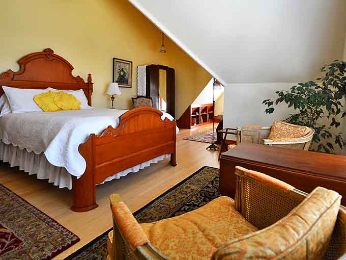 The sloped ceilings create a sanctuary where Victorian elegance meets attic charm&mdash;a room that feels both grand and intimate simultaneously.