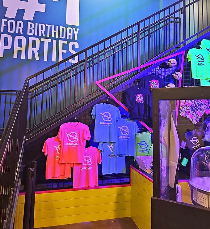 The merchandise wall offers colorful souvenirs &ndash; because nothing says "I survived Urban Air" like a neon t-shirt.