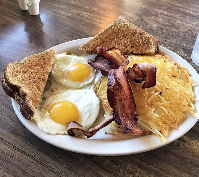 The breakfast trifecta &ndash; perfectly fried eggs, crispy bacon, and hashbrowns with that magical crisp-outside-tender-inside texture that's impossible to replicate at home.