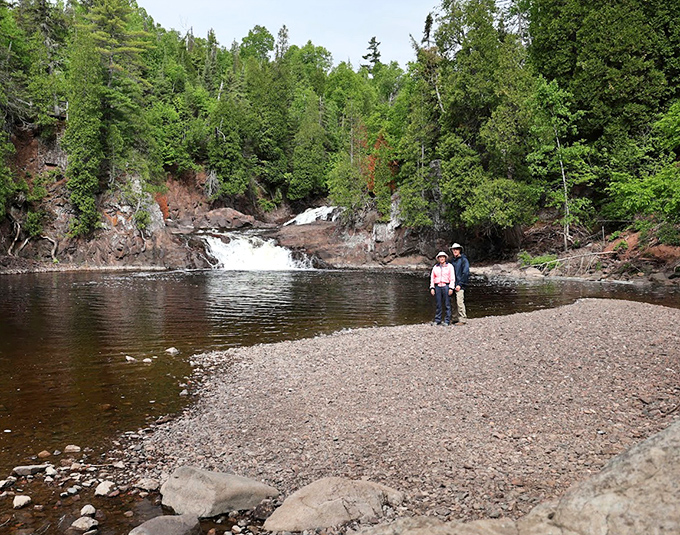 The calm pool below the falls offers a moment of tranquility, like nature hitting the pause button just for you.