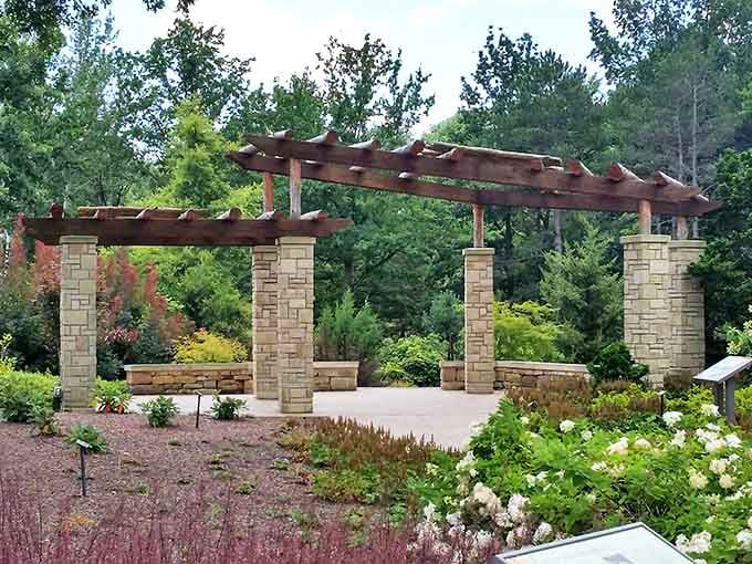This elegant garden structure frames the surrounding landscape like a living painting, inviting contemplation and quiet conversation.
