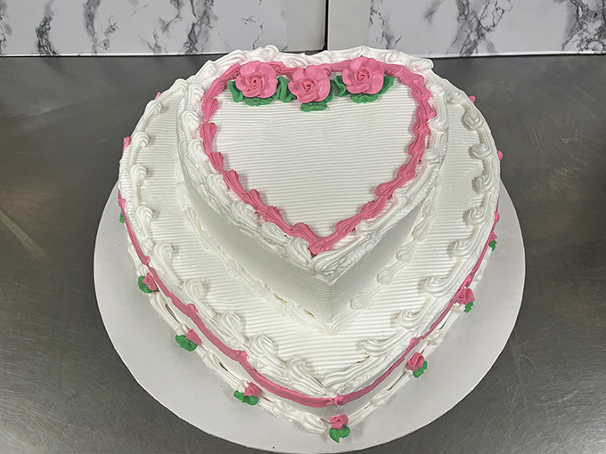 Love takes shape in this heart-themed cake, where delicate pink piping and rose decorations create a romantic dessert masterpiece.